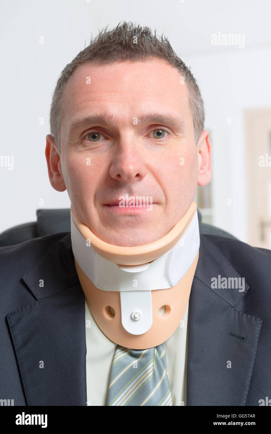 Man with a surgical cervical collar suffering from neck pain at work ...