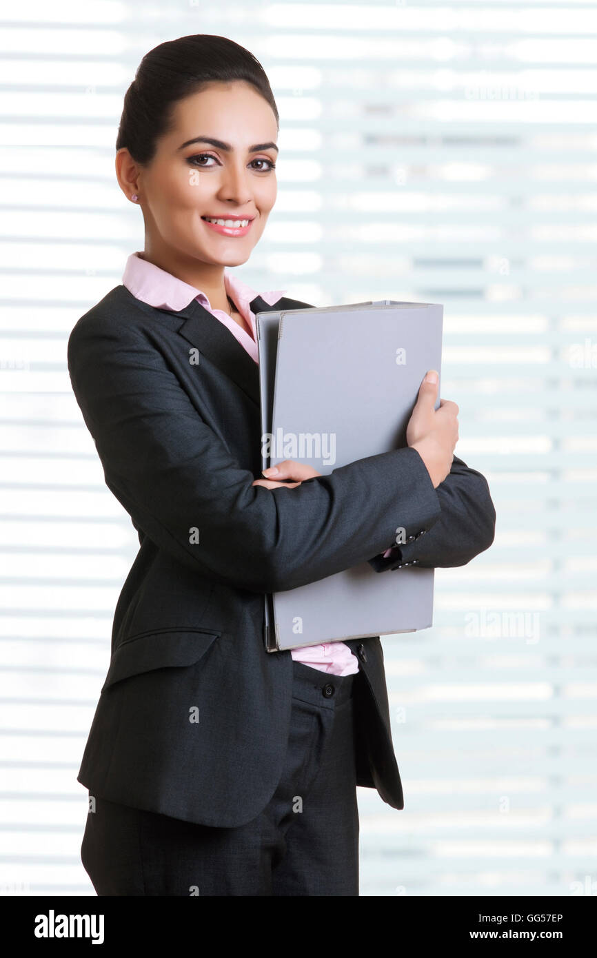 Portrait of confident woman with file folder in office Stock Photo - Alamy