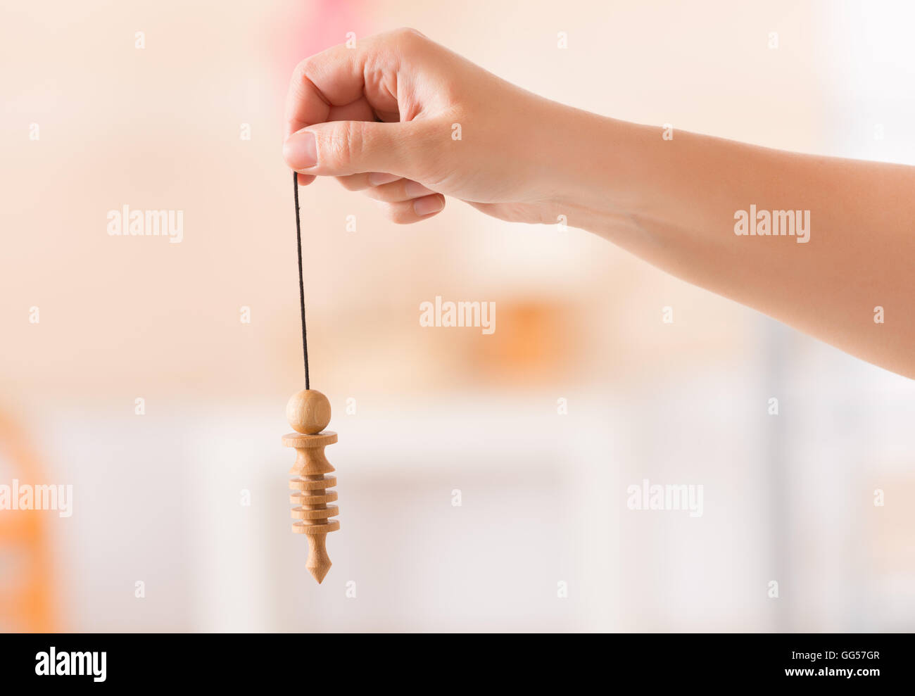 Hand with pendulum, tool for dowsing Stock Photo - Alamy