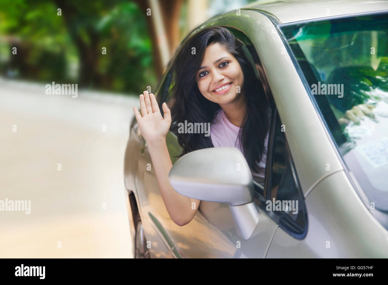 Portrait of beautiful Indian woman waving out of car window Stock Photo ...