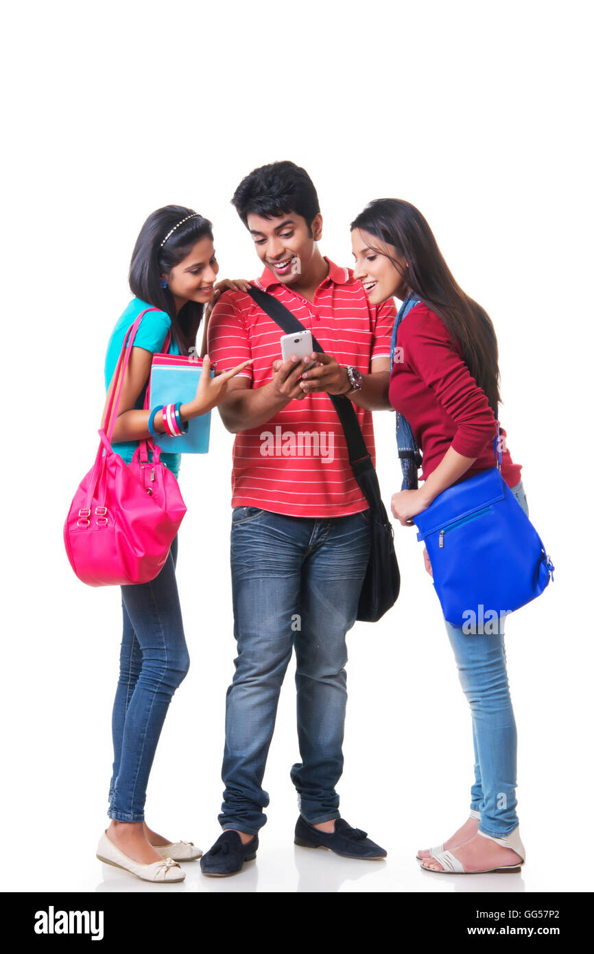 Full length of happy college students using mobile phone against white ...