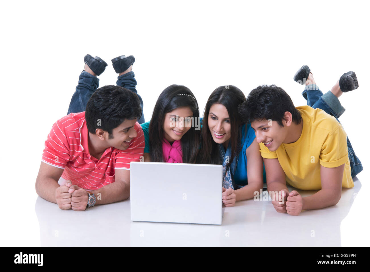 Happy friends using laptop against white background Stock Photo - Alamy