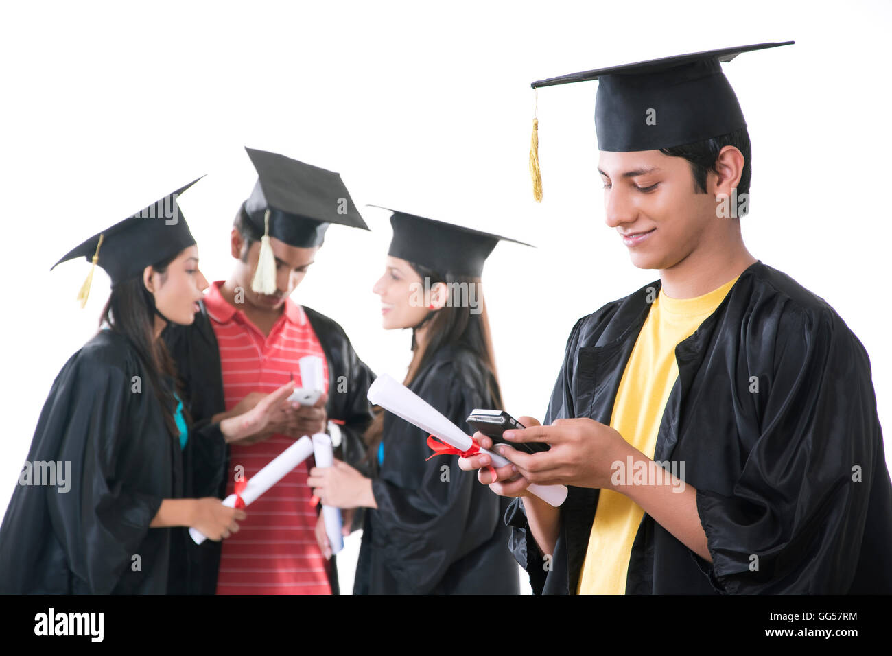 Male graduate student using mobile phone with friends discussing over ...