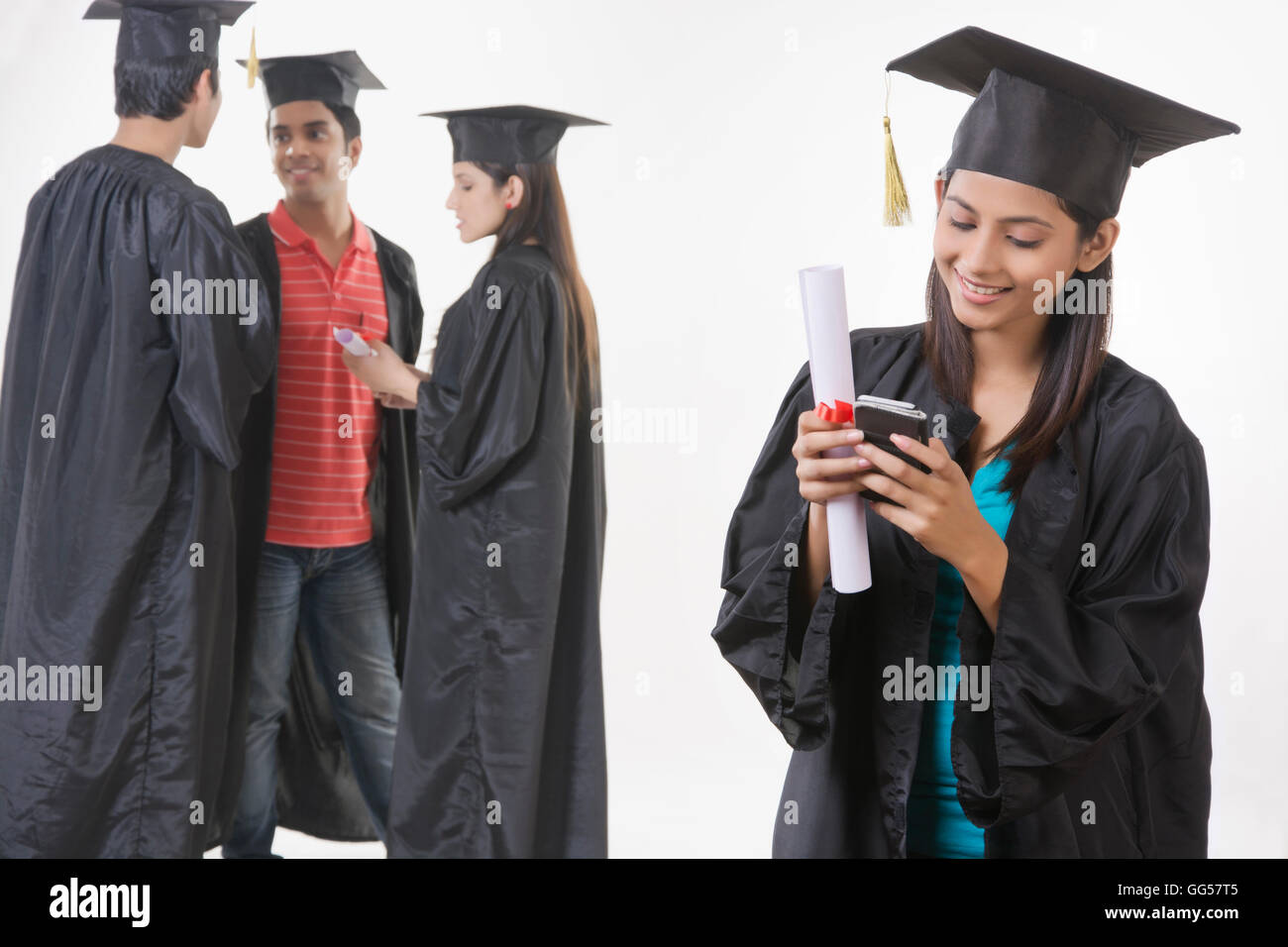 Beautiful graduate student using mobile phone with friends discussing ...