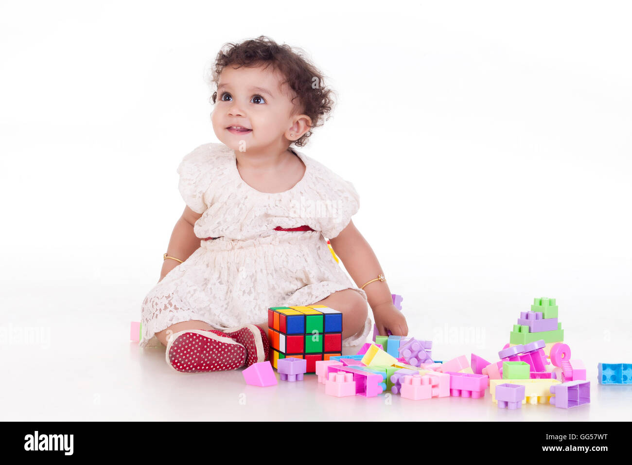 Full length of smiling cute girl with blocks against white background ...