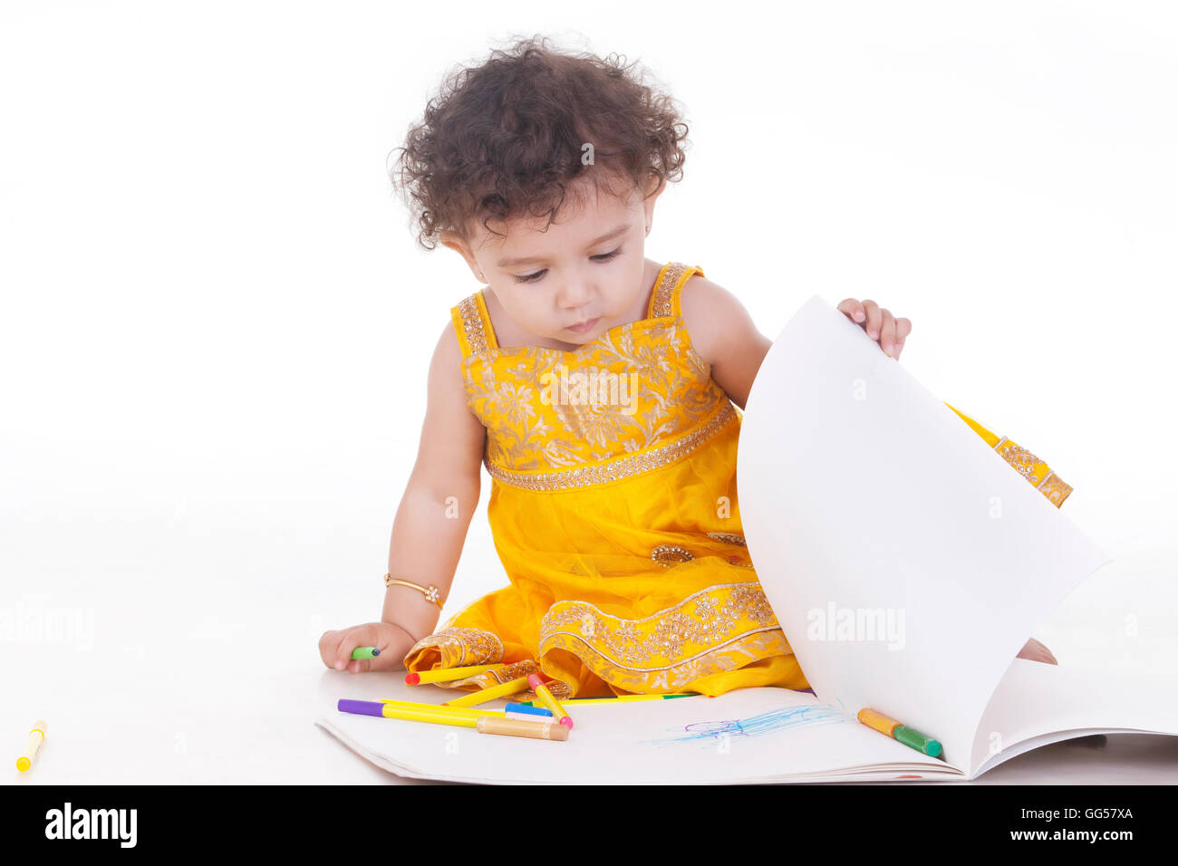Cute girl turning page against white background Stock Photo - Alamy
