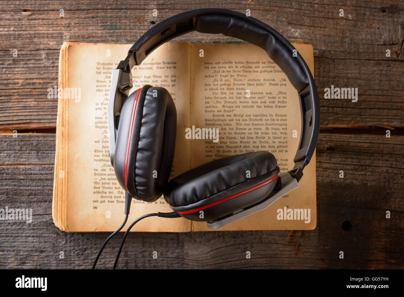 Headphones on the old book. Concept of listening to audiobooks Stock ...