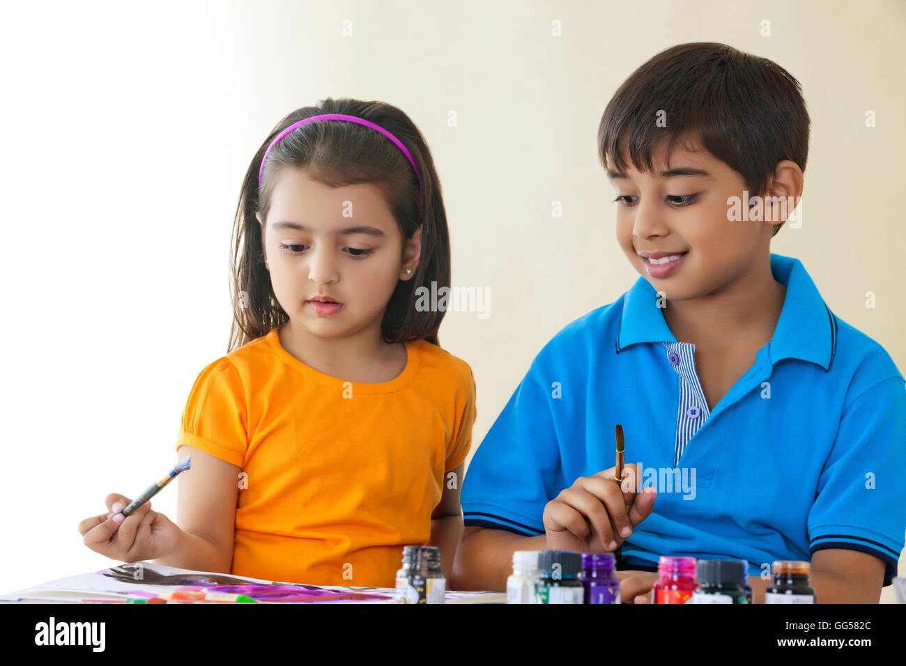 Cute siblings coloring against colored background Stock Photo - Alamy