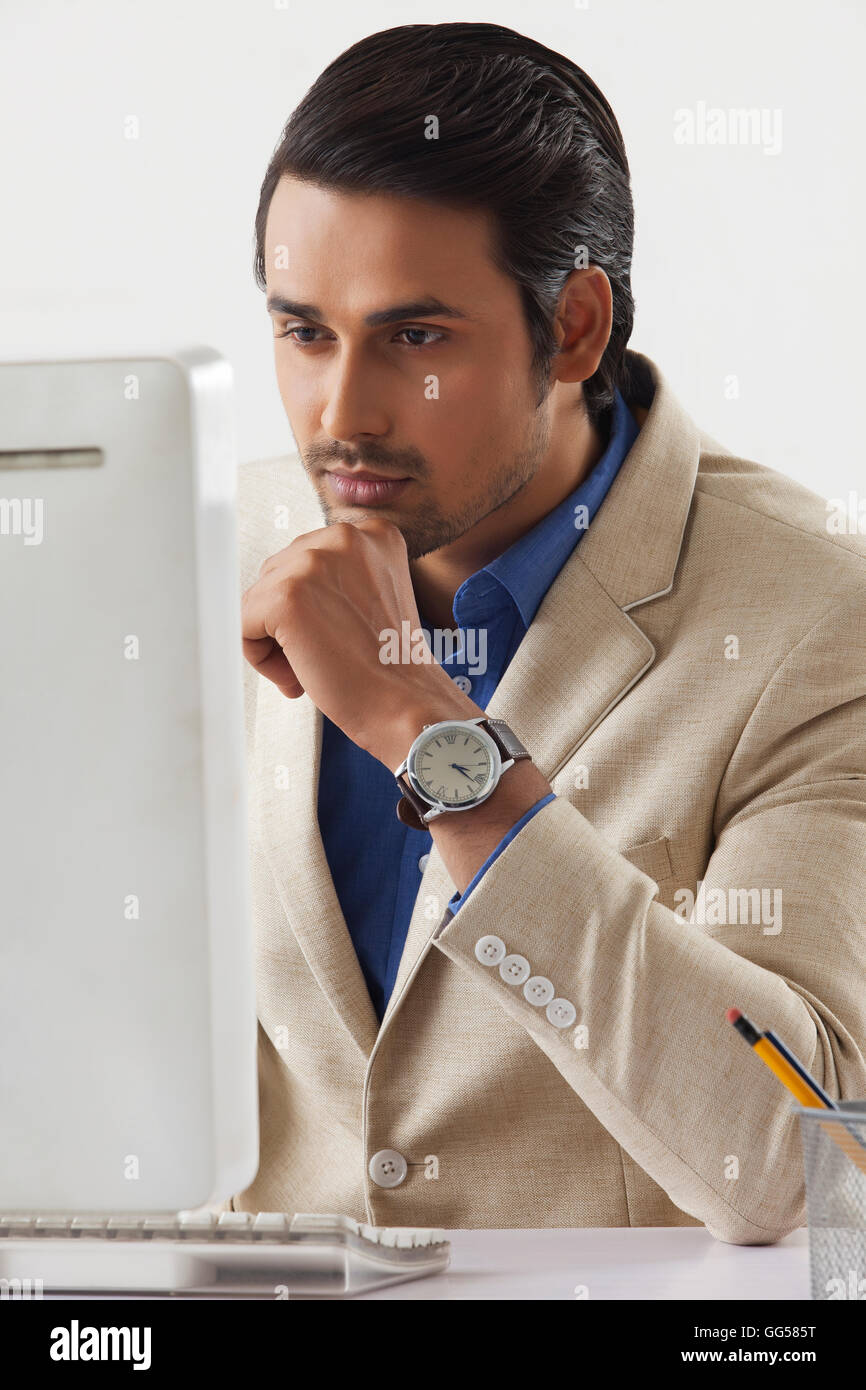 Concentrated Indian businessman using computer in office Stock Photo ...