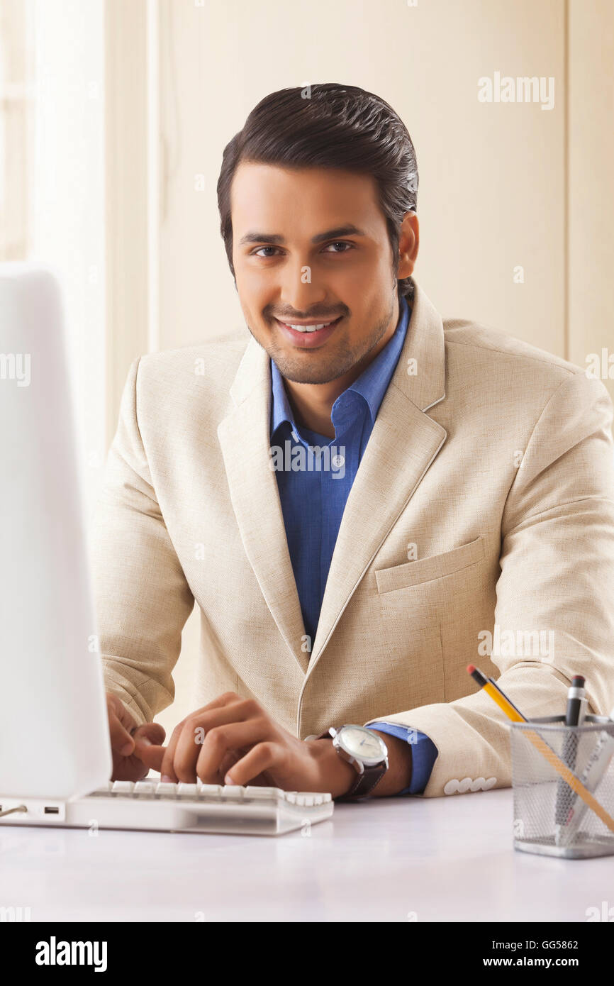 Portrait of handsome young businessman using computer in office Stock ...