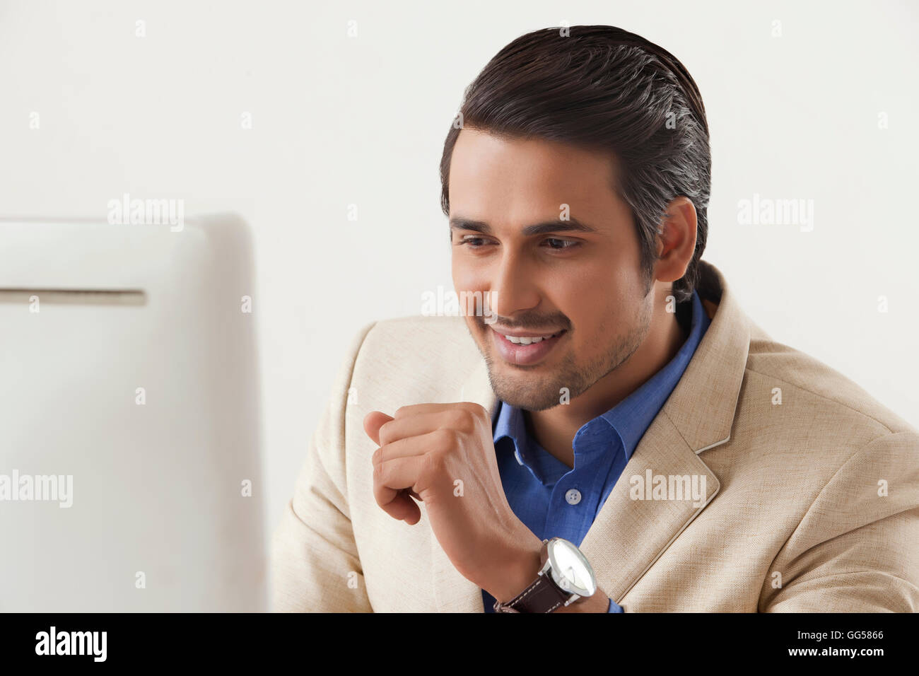 Confident young businessman using computer in office Stock Photo - Alamy