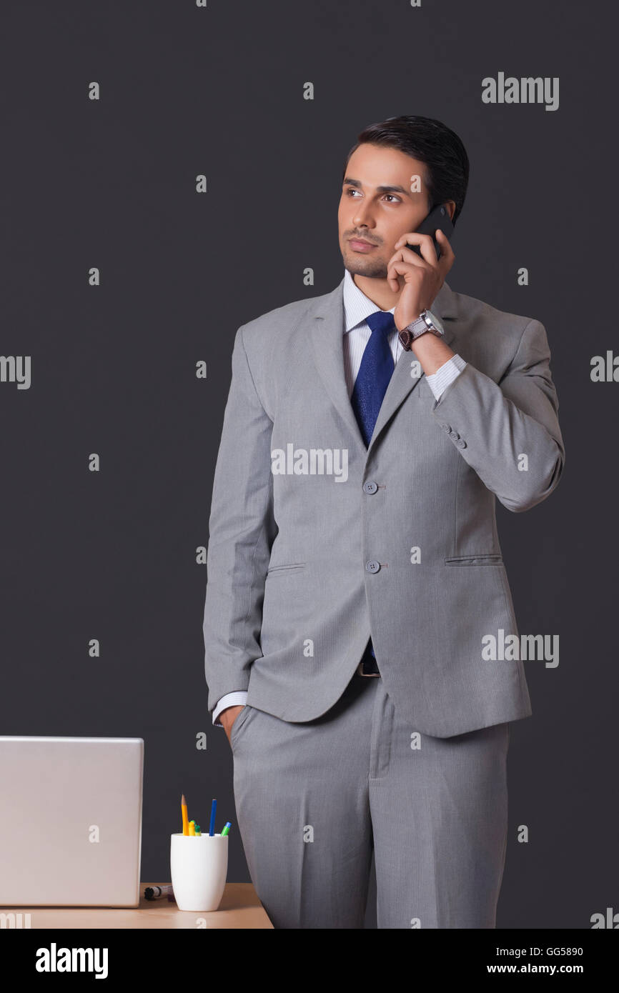Young Indian businessman using mobile phone in office Stock Photo - Alamy