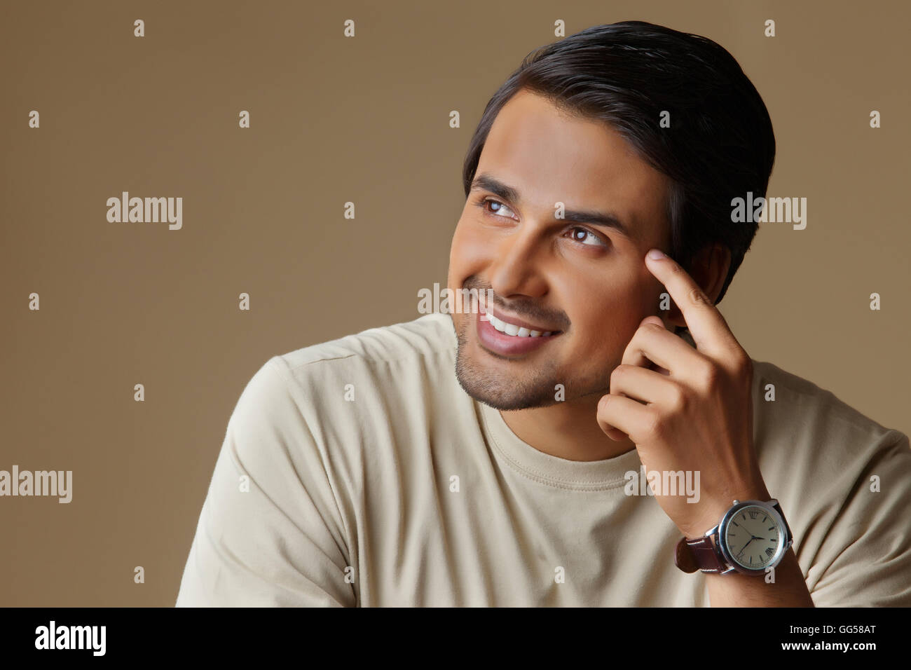 Thoughtful Indian man looking at copy space over colored background ...