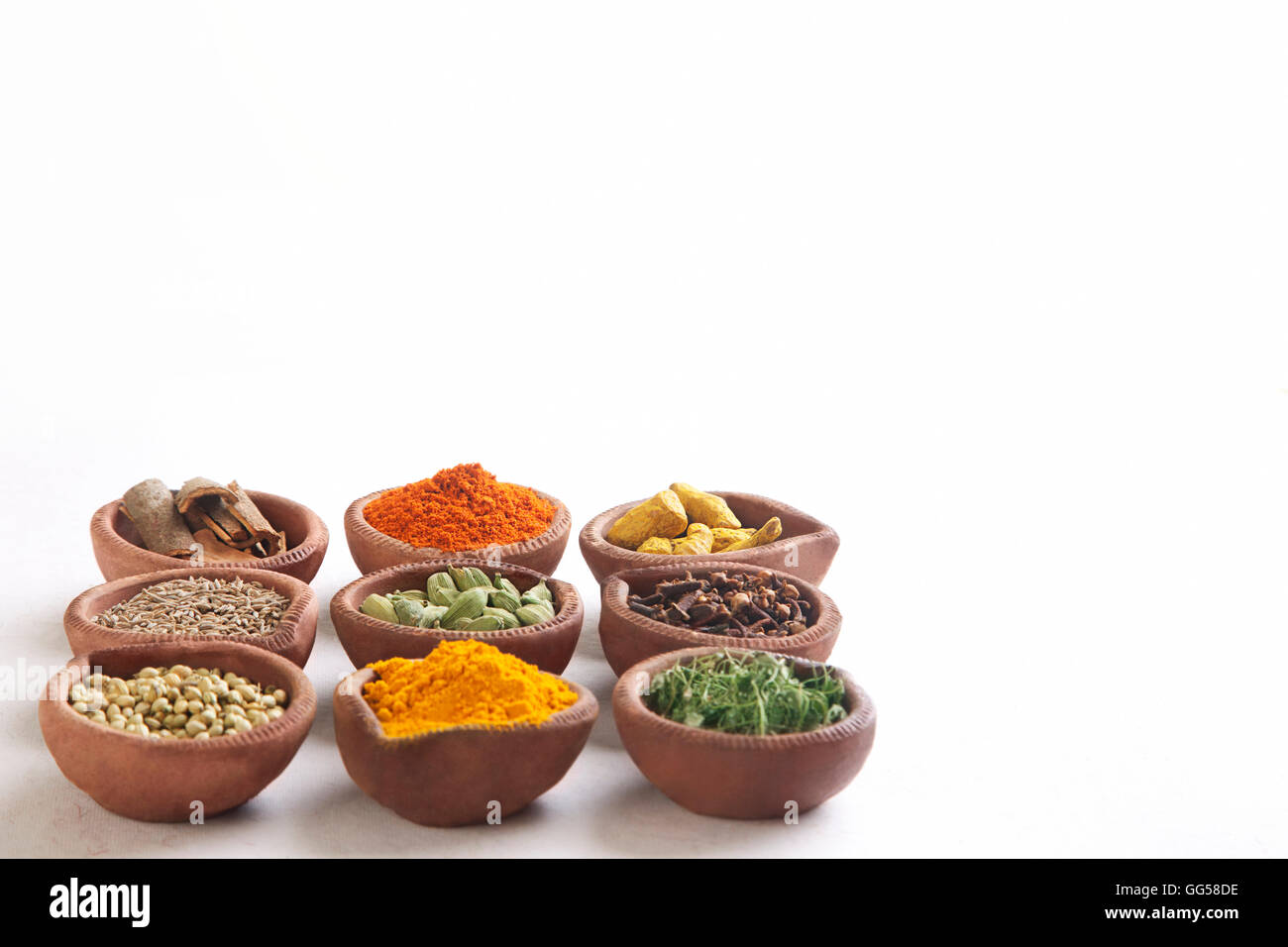 Variety of Indian spices in oil lamps over white background Stock Photo ...