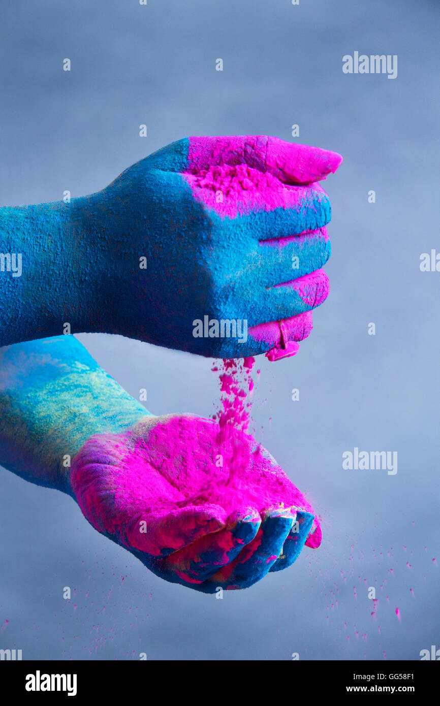 Close-up of blue colored hands holding pink powder paint Stock Photo ...