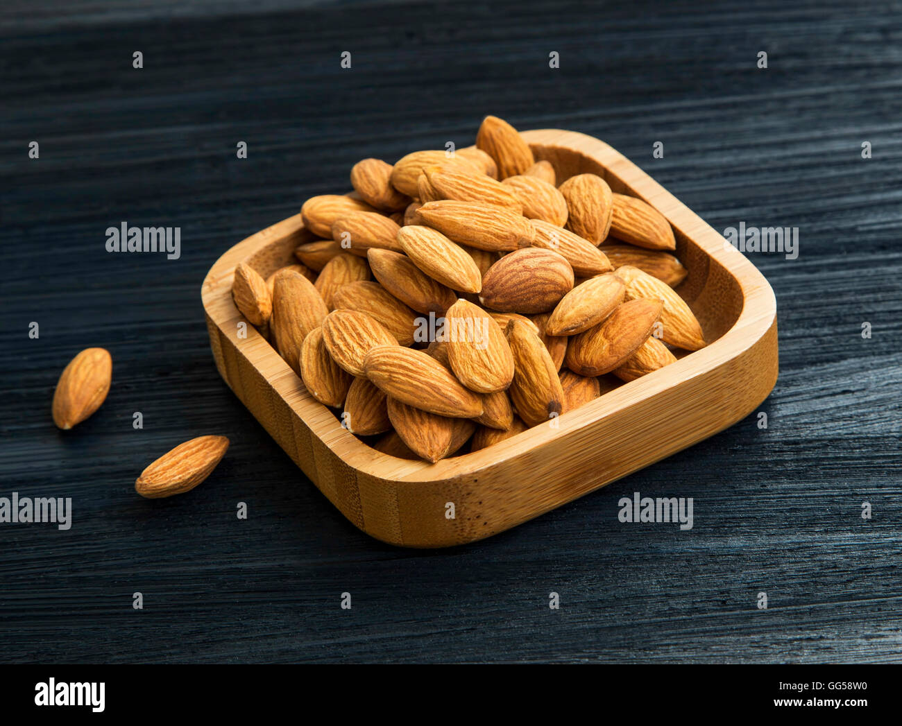 Fresh almonds nuts in wooden bamboo bowl , healthy brown nuts Stock ...
