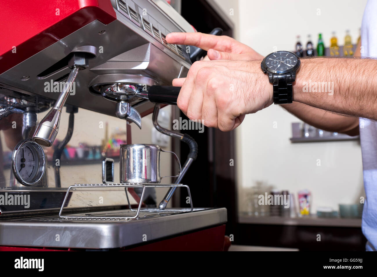 A handsome young man making coffee at the bar in a coffee shop Stock ...