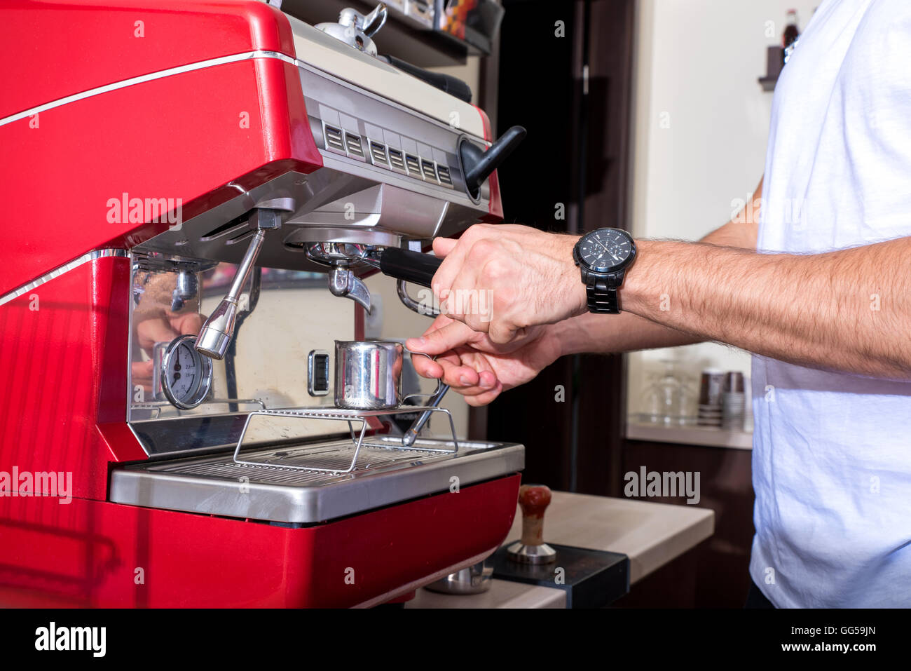 A handsome young man making coffee at the bar in a coffee shop Stock ...