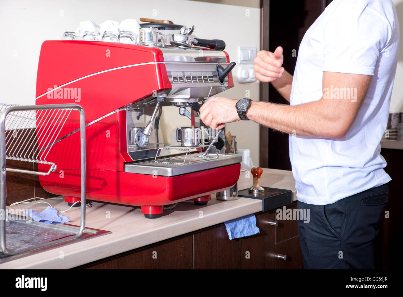 A handsome young man making coffee at the bar in a coffee shop Stock ...