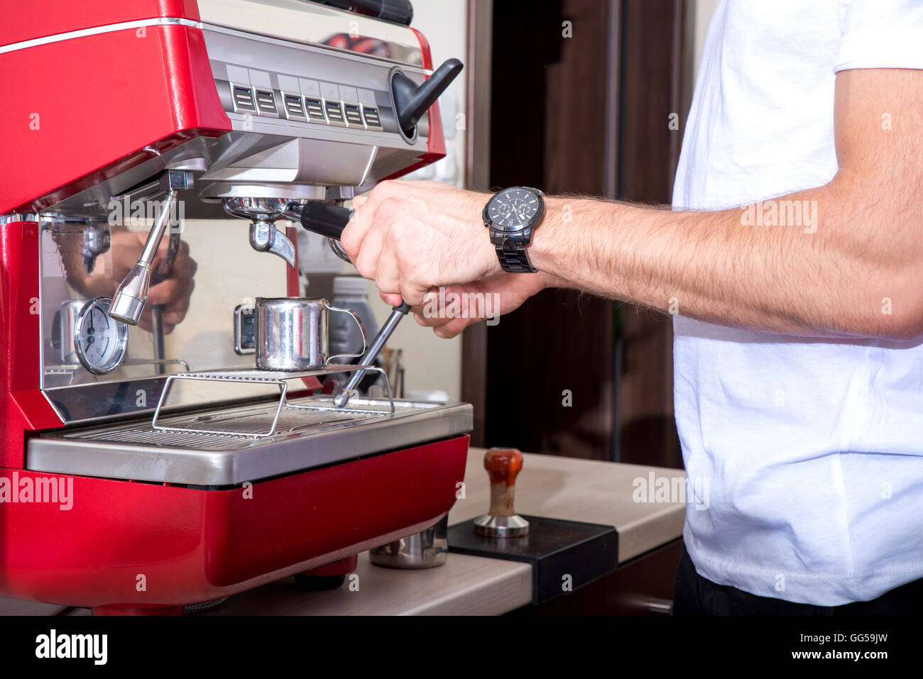 A handsome young man making coffee at the bar in a coffee shop Stock ...