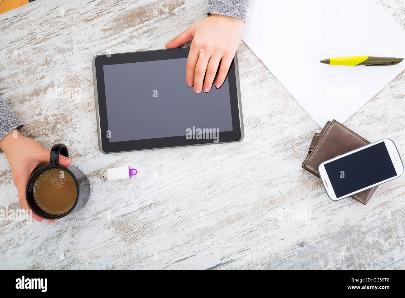 A woman’s hand at a table useing a tablet Stock Photo - Alamy