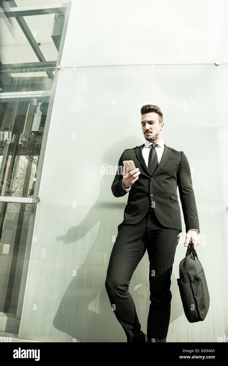 A business man standing in front of a modern office building Stock ...