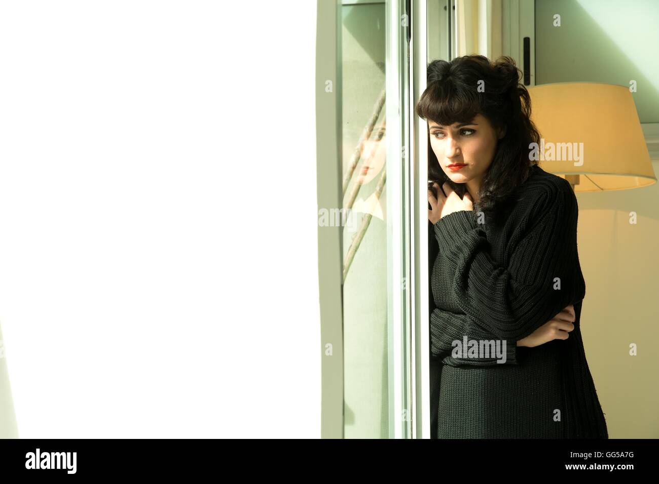 A melancholic, retro styled girl standing at the window Stock Photo - Alamy