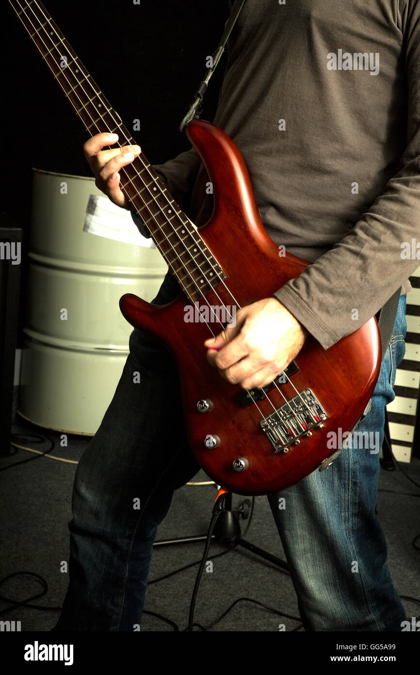 A Rock musician playing passionately bass in the rehearsal Studio Stock ...