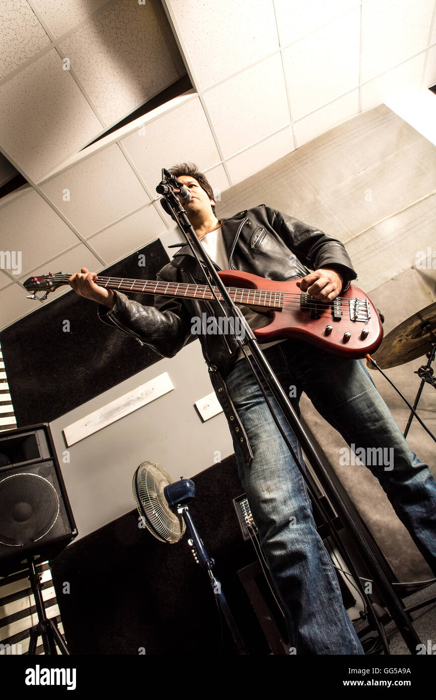 A Rock singer playing bass in the rehearsal Studio Stock Photo - Alamy