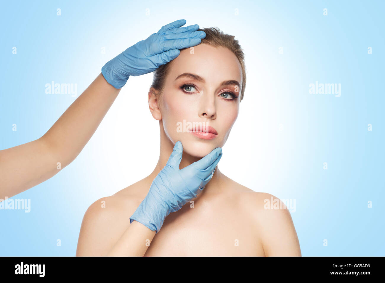 surgeon or beautician hands touching woman face Stock Photo - Alamy