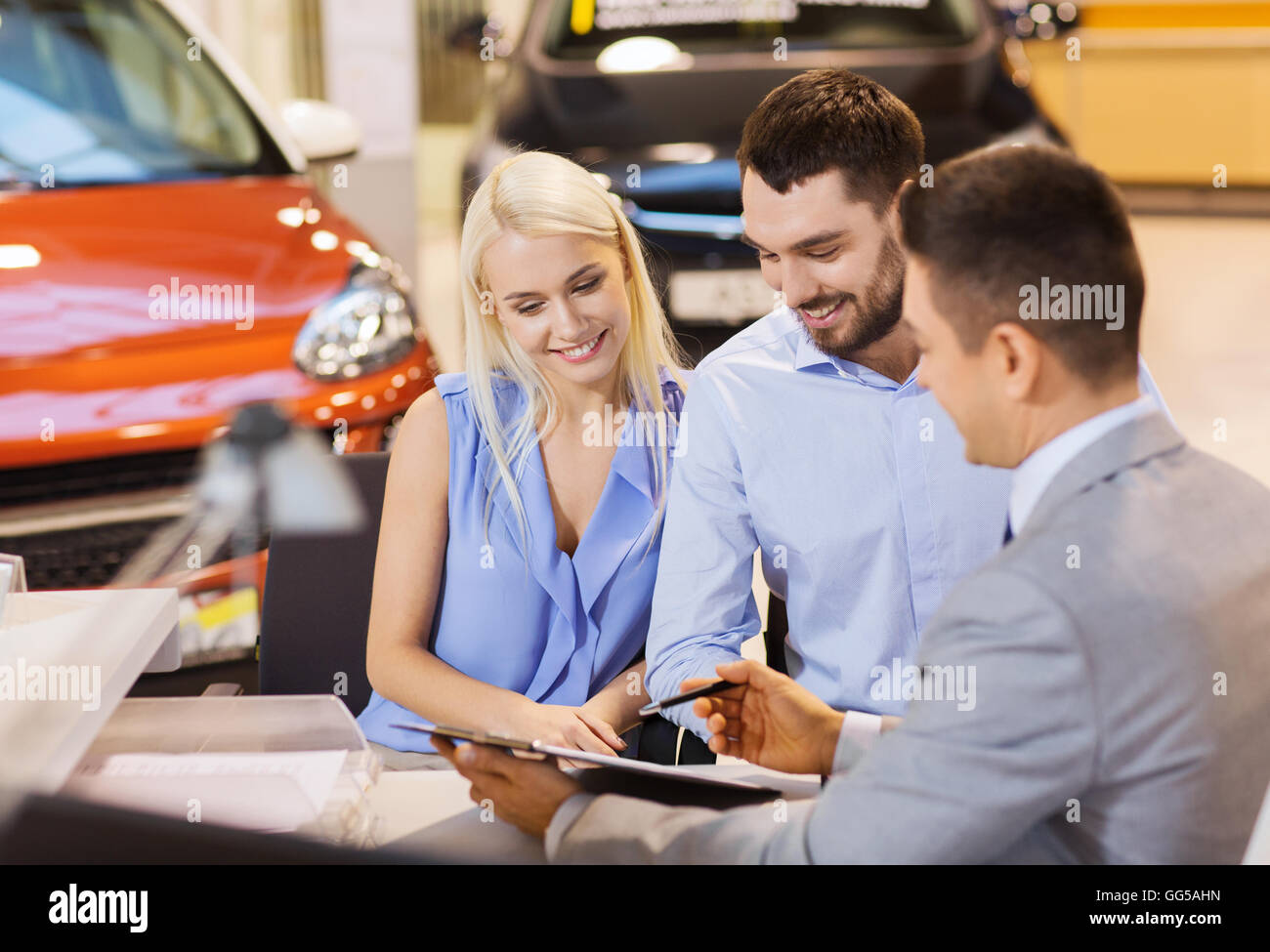 happy couple with car dealer in auto show or salon Stock Photo - Alamy