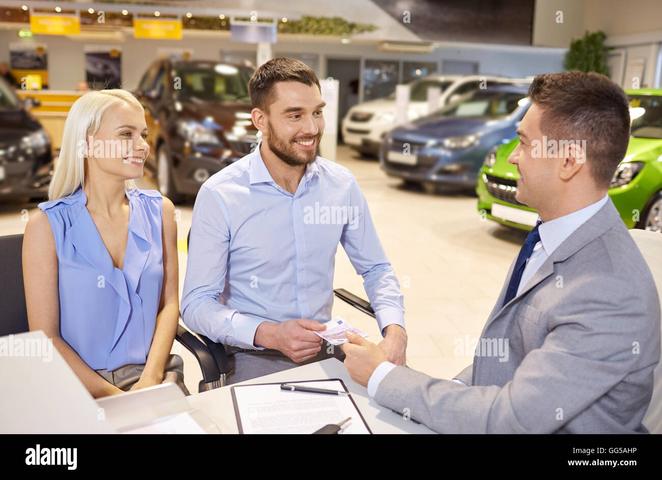 happy couple with car dealer in auto show or salon Stock Photo - Alamy
