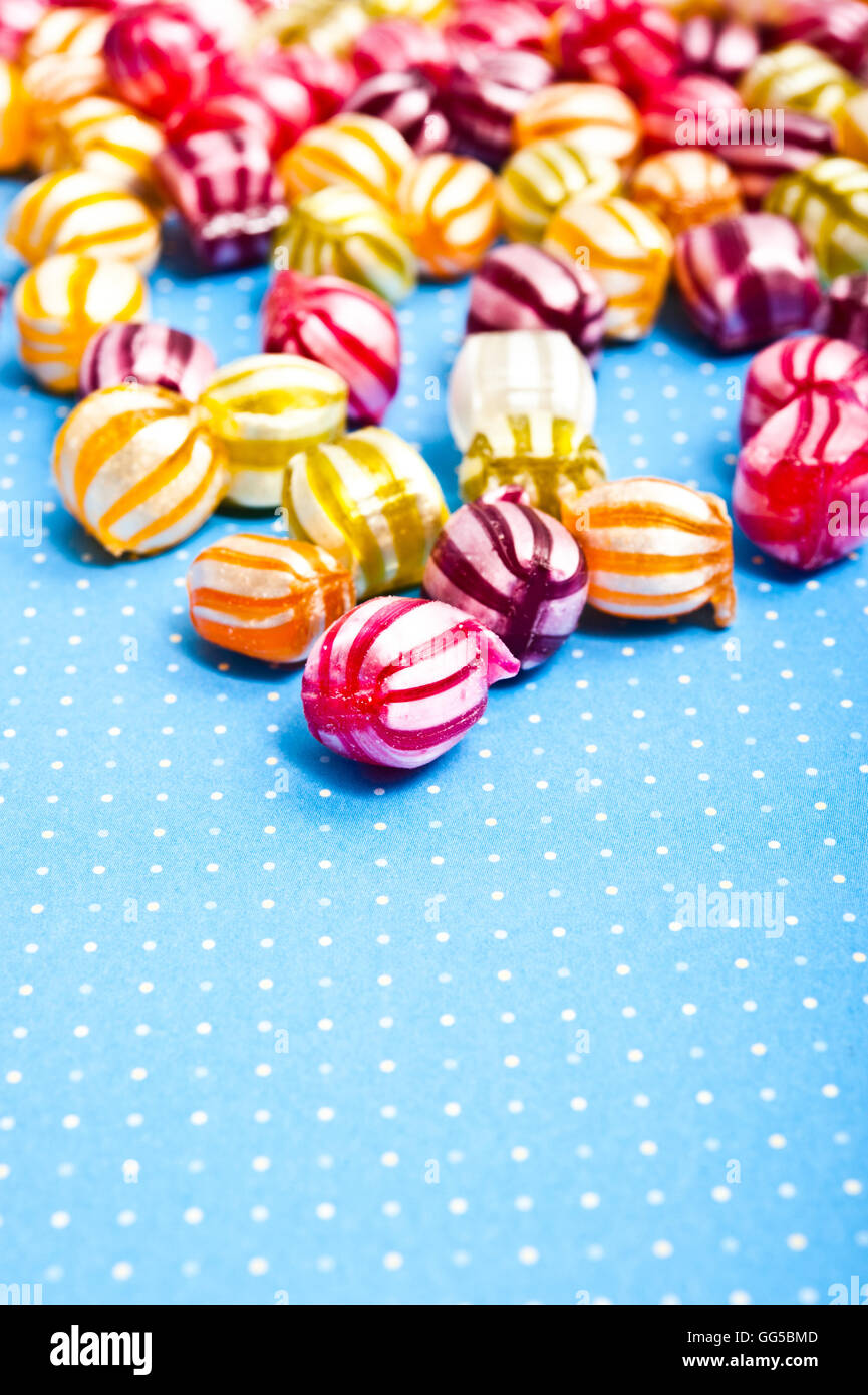 candies scattered on blue background Stock Photo - Alamy