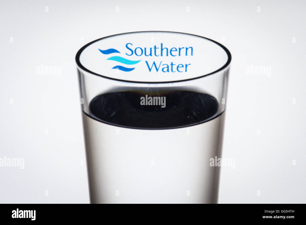 The logo of water company Southern Water seen through a glass of water ...