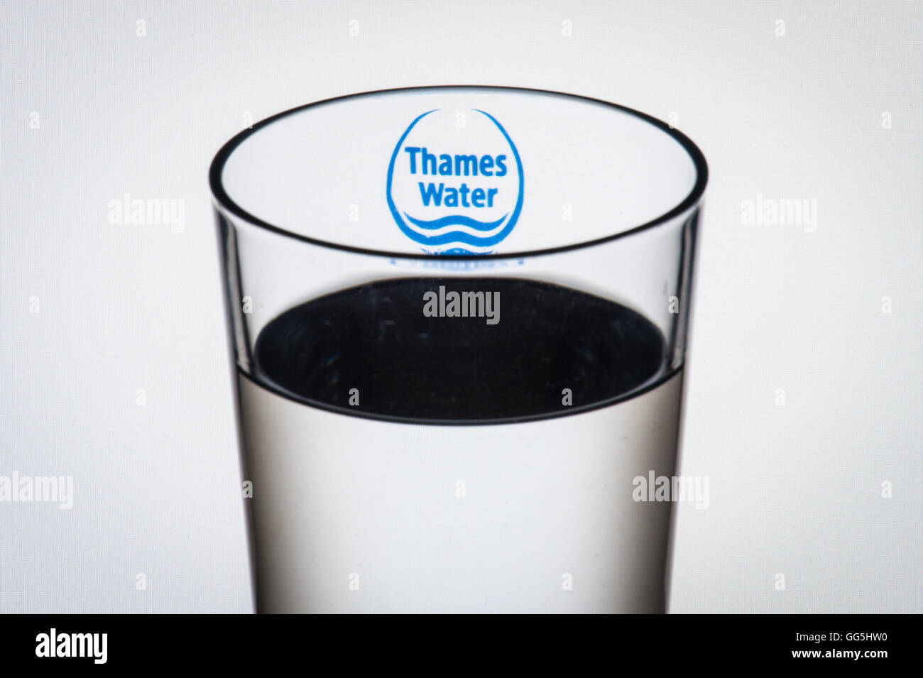 The logo of water company Thames Water seen through a glass of water ...