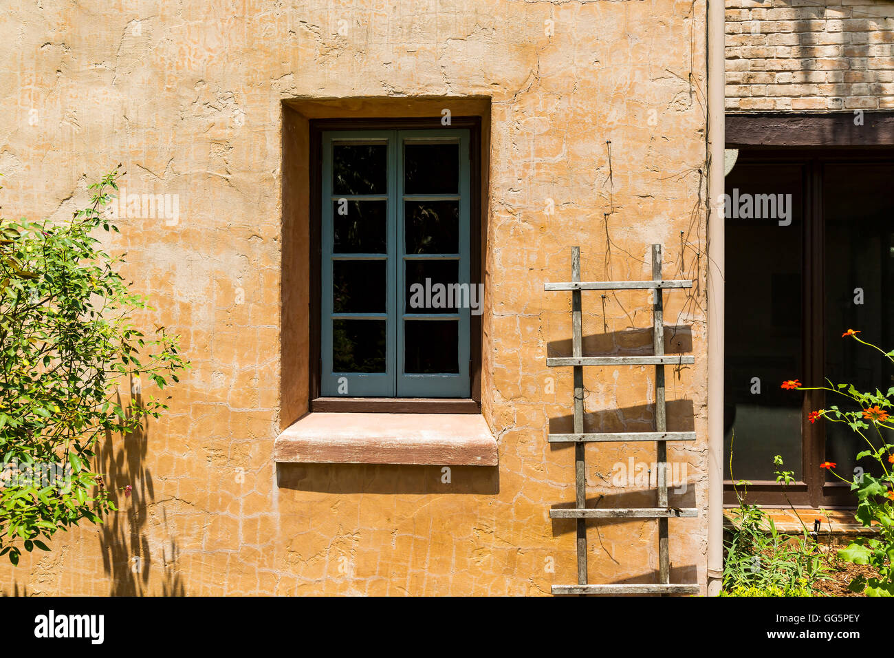 Rustic ladder on a wall next to a window Stock Photo - Alamy