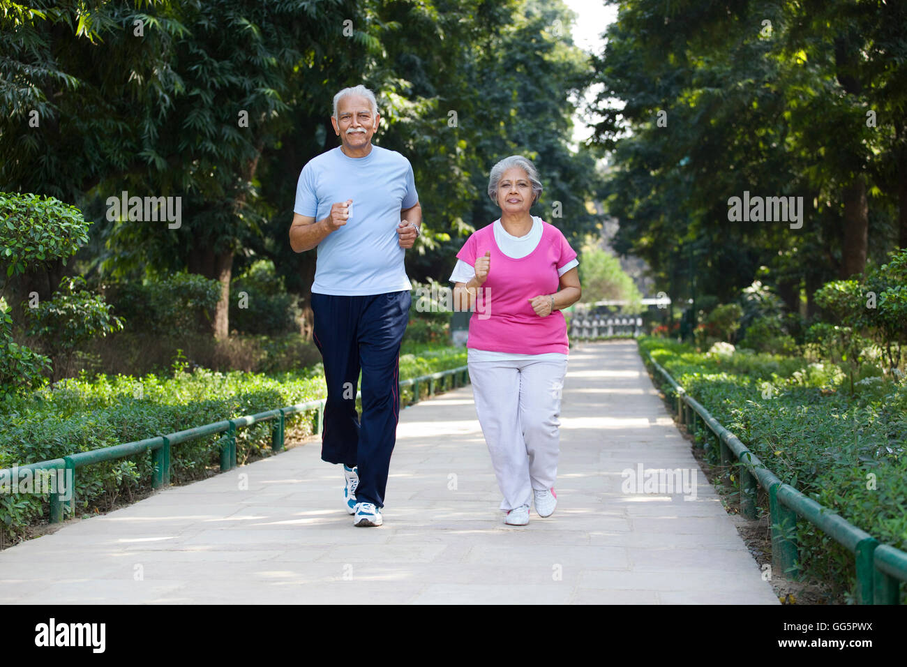 Elderly couple jogging in park Stock Photo - Alamy