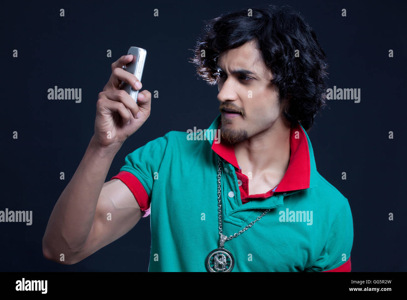 Close-up of young man reading text message against black background ...