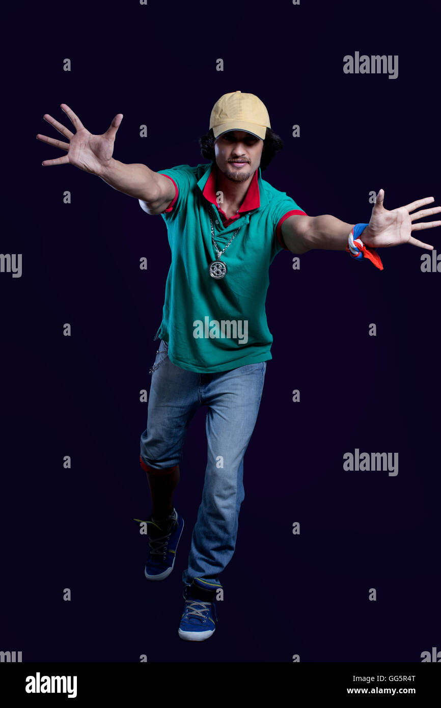 Full length of young man in casual clothing dancing against black ...