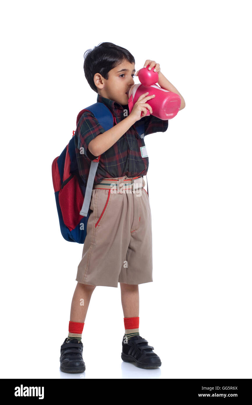 Student drinking water from water bottle against white background Stock ...