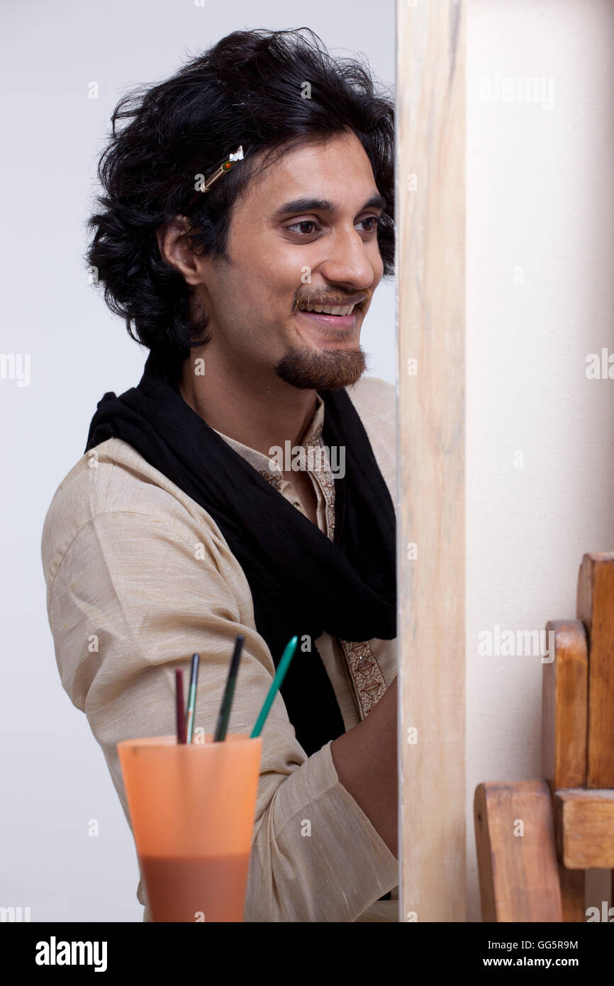 Handsome smiling artist painting Stock Photo - Alamy