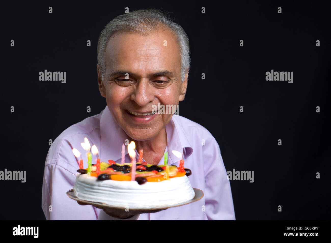 Smiling senior man looking at cake Stock Photo - Alamy
