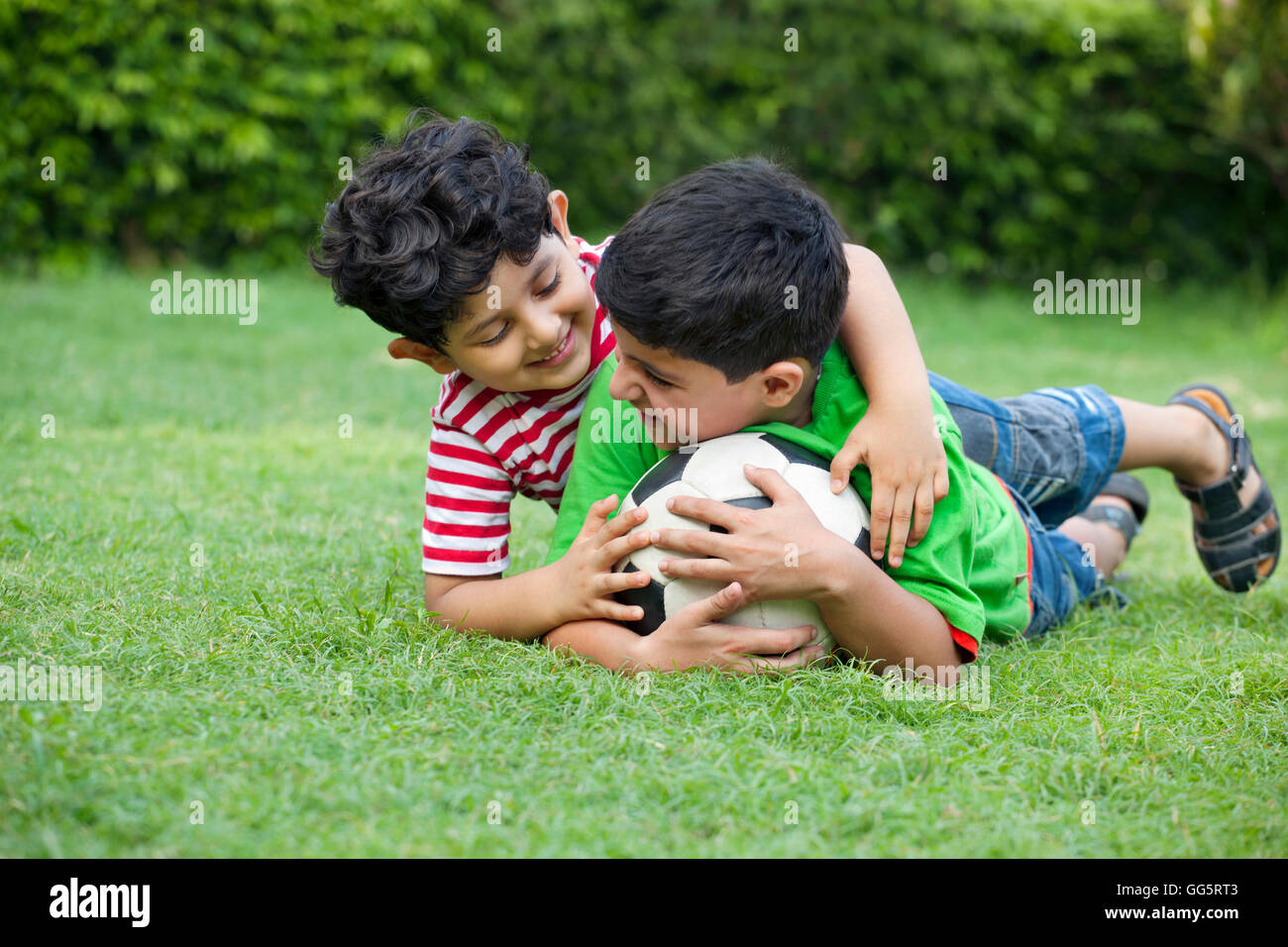Brothers playing with soccer ball in park Stock Photo - Alamy