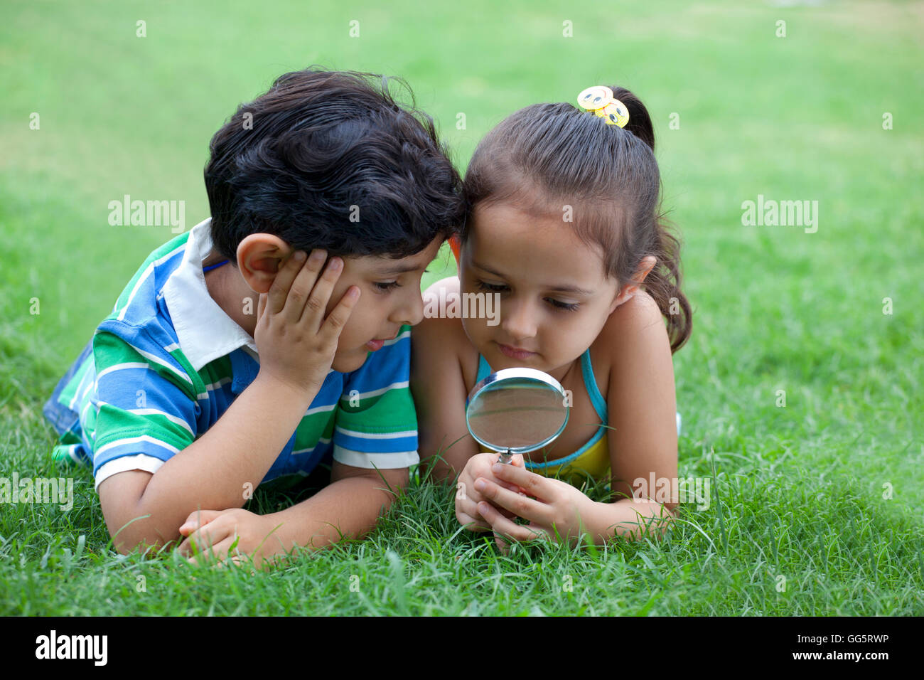 Children looking through magnifying glass Stock Photo - Alamy