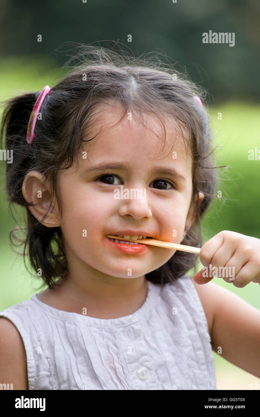 Portrait of cute little girl holding candy stick Stock Photo - Alamy