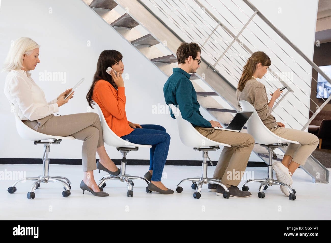 Four people sitting on chairs hi-res stock photography and images - Alamy