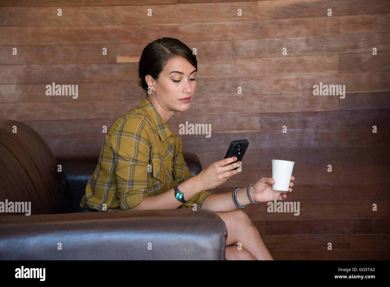 Young woman using a mobile phone during office break Stock Photo - Alamy