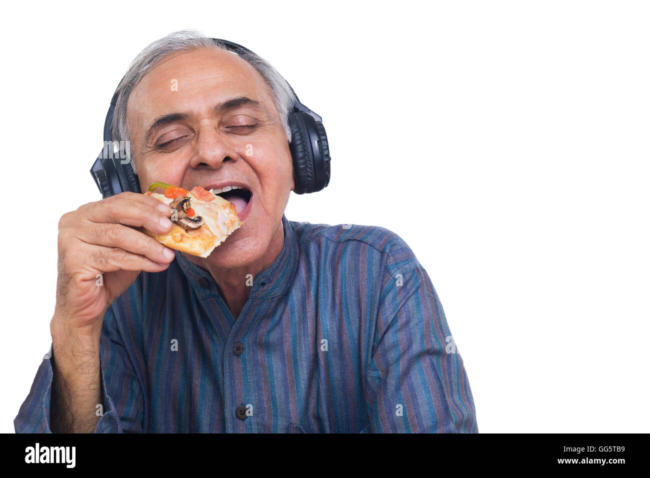 Close-up of senior man eating pizza while listening to music Stock ...