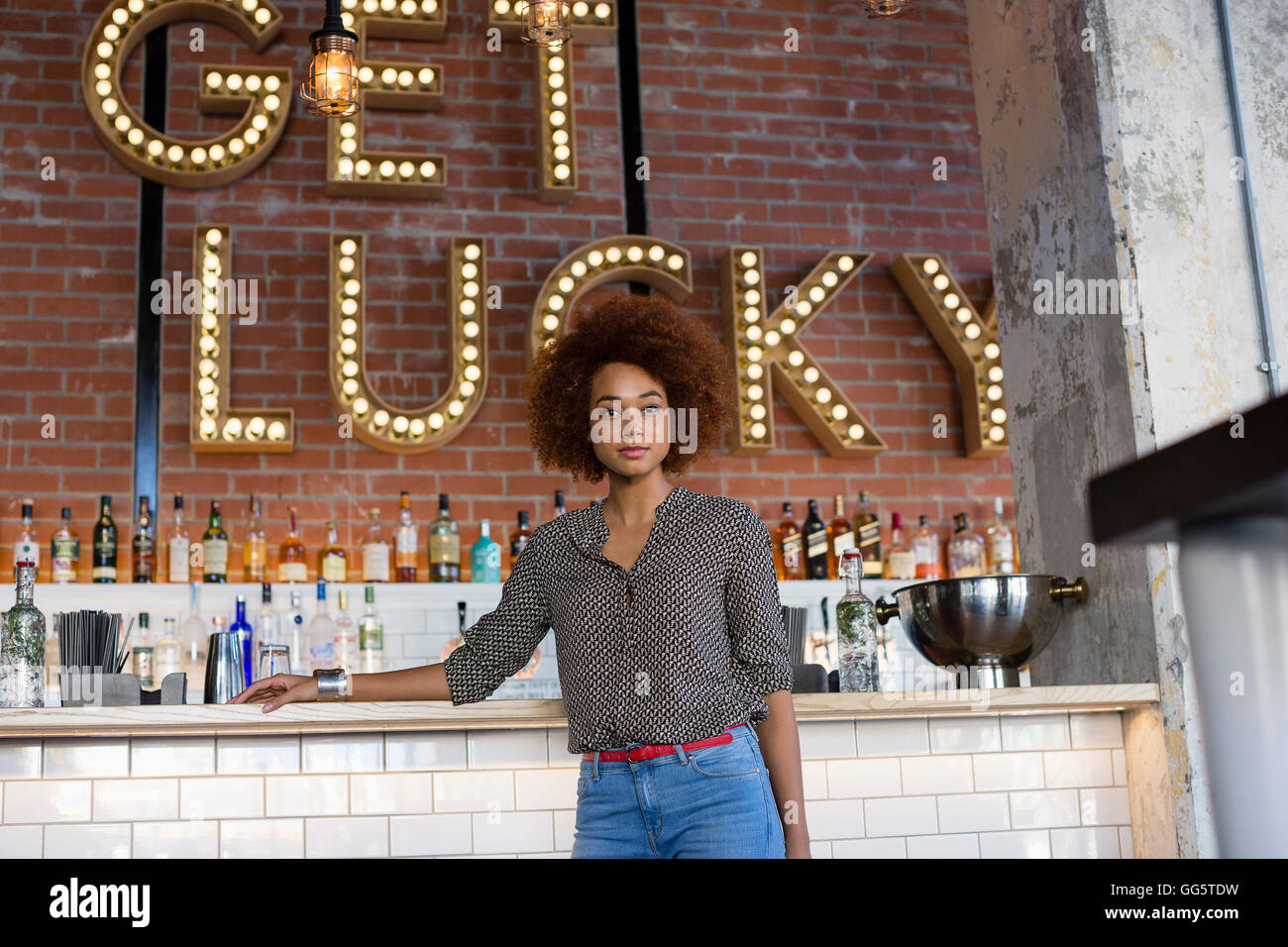 Portrait of a young woman standing at bar counter Stock Photo - Alamy