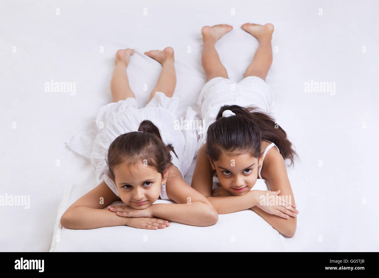 Portrait of sisters lying on bed Stock Photo - Alamy